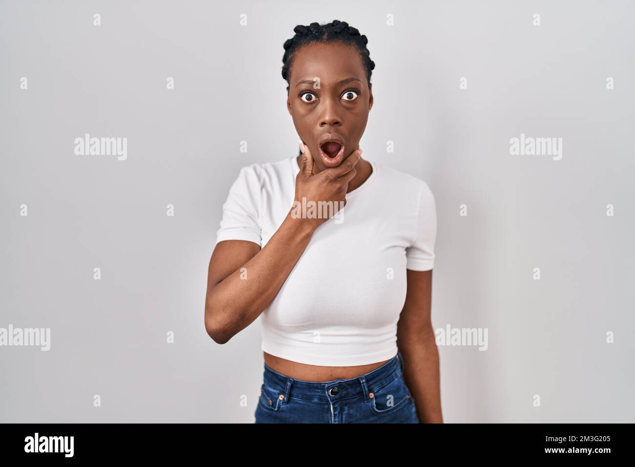 Beautiful black woman standing over isolated background looking ...
