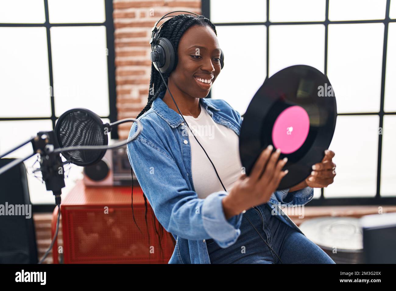 African american woman artist smiling confident holding vinyl disc at ...