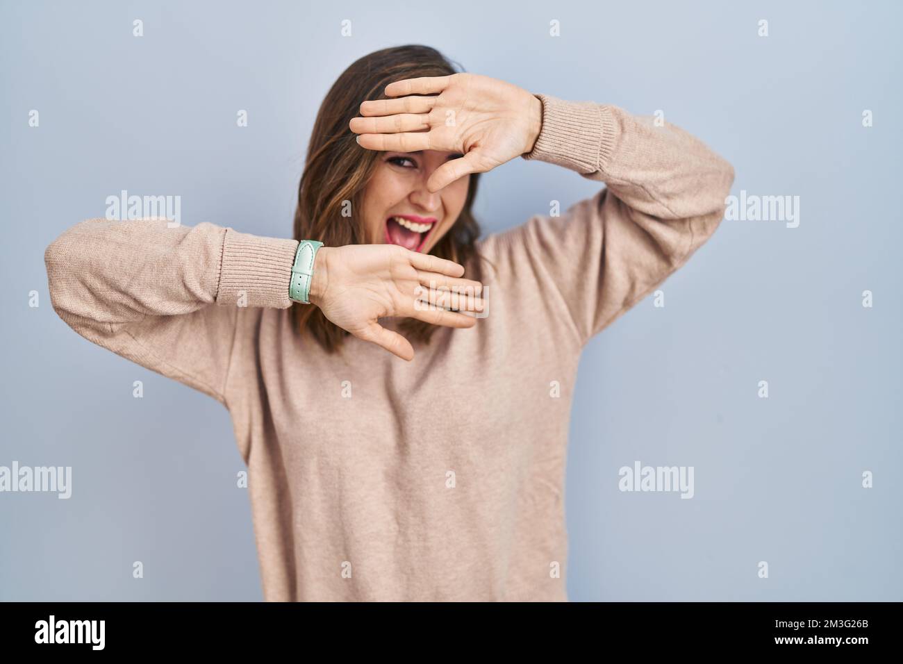 Young woman standing over isolated background smiling cheerful playing ...