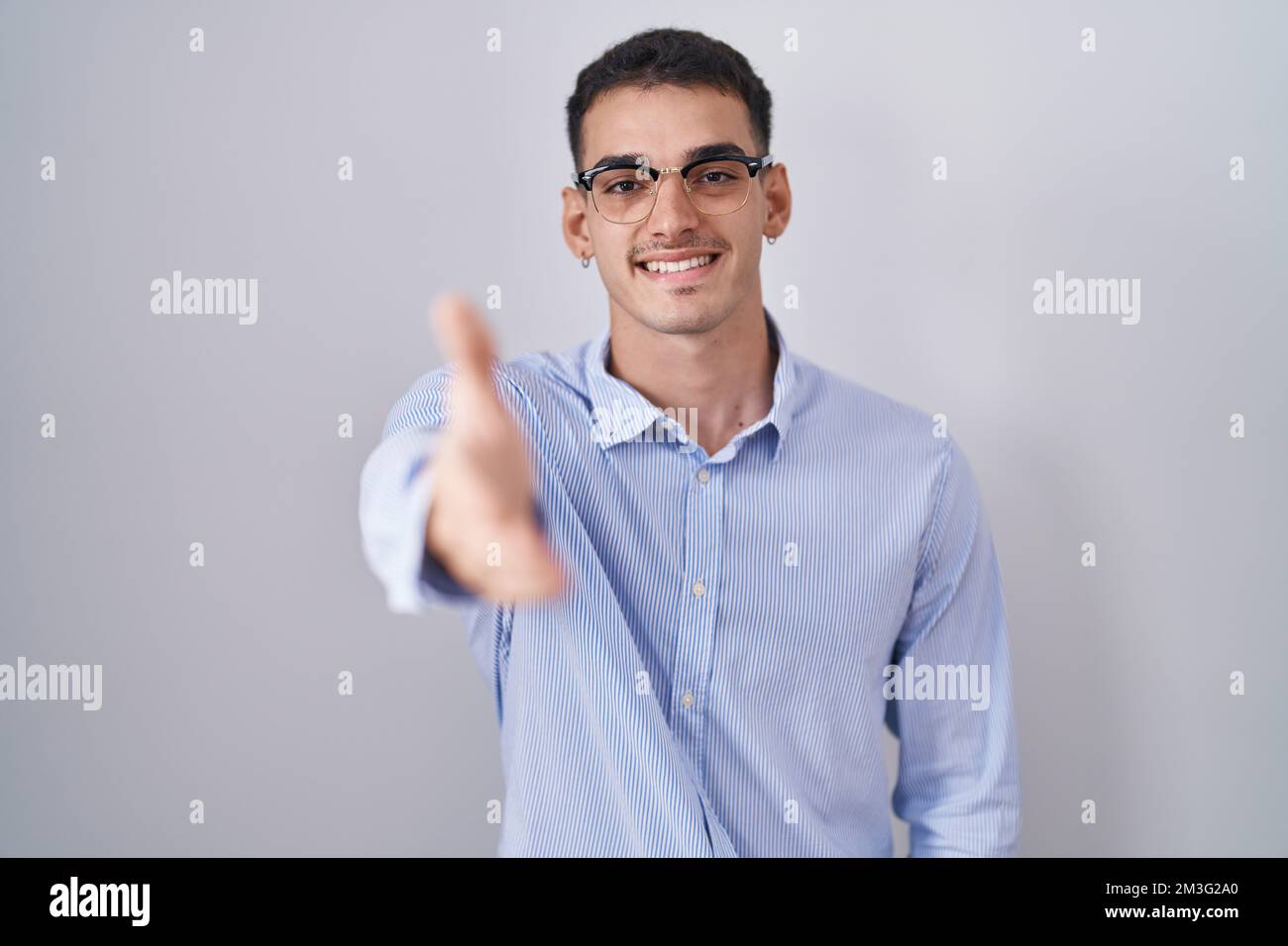 Handsome hispanic man wearing business clothes and glasses smiling ...