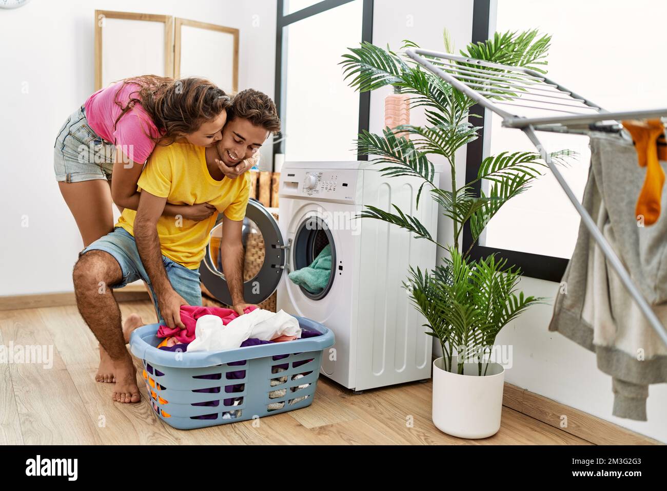 Man and woman couple cleaning clothes using washing machine at laundry ...