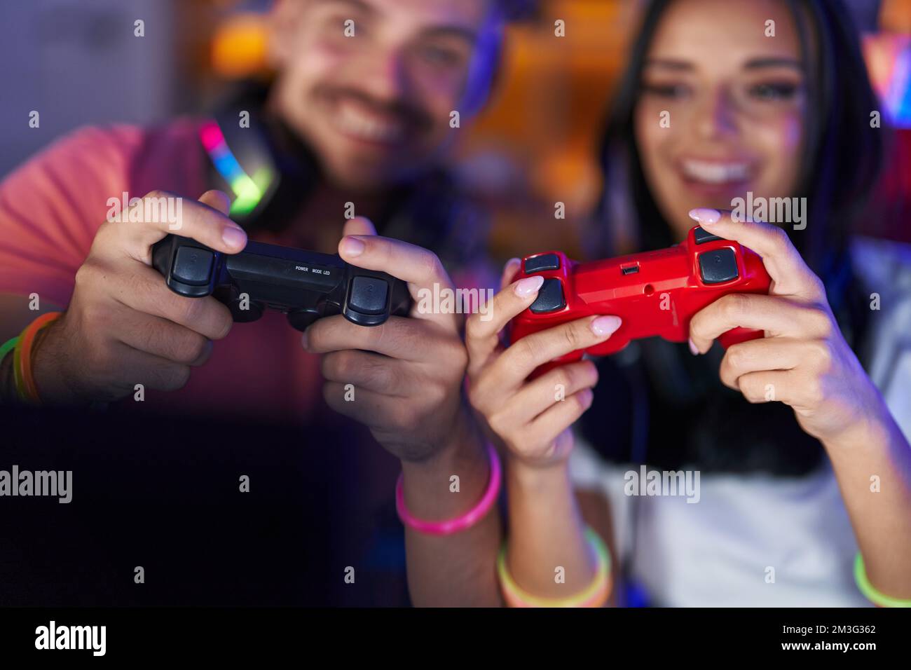 Man and woman streamers playing video game using computer and joystick ...