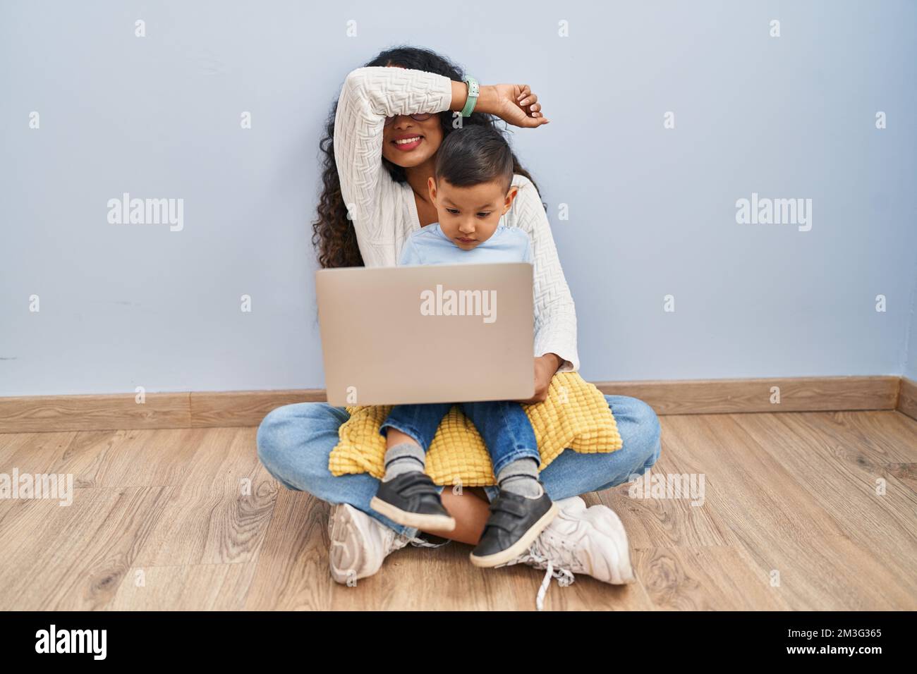 Young hispanic mother and kid using computer laptop sitting on the ...