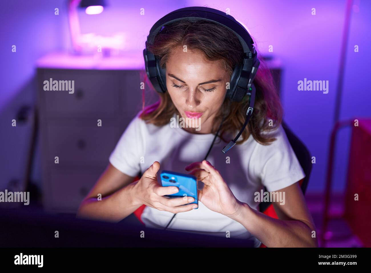 Young beautiful hispanic woman streamer using computer and smartphone ...