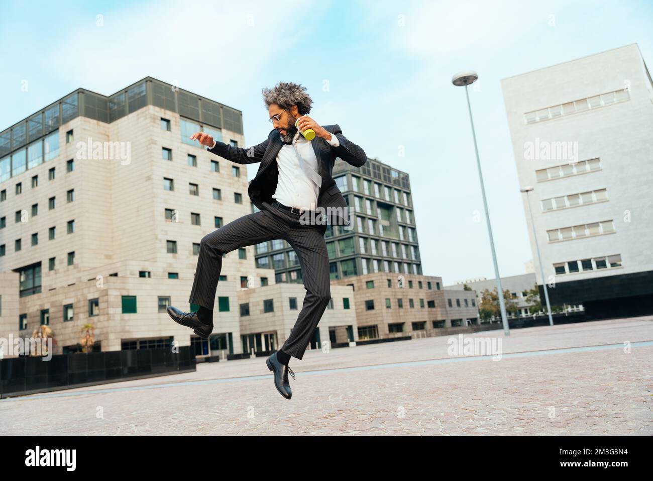 Young entrepreneur jumping and dancing to celebrate his successful day ...