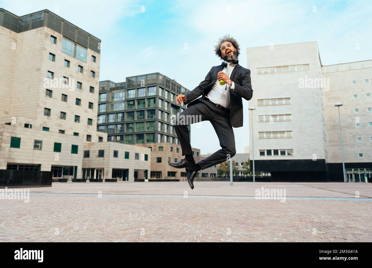 Young entrepreneur jumping and dancing to celebrate his successful day ...