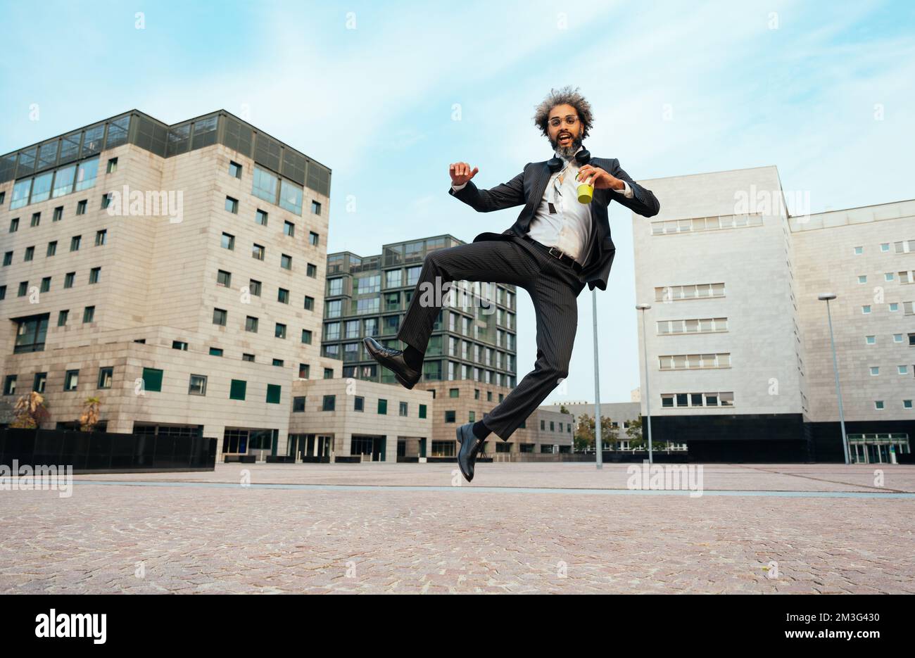 Young entrepreneur jumping and dancing to celebrate his successful day ...