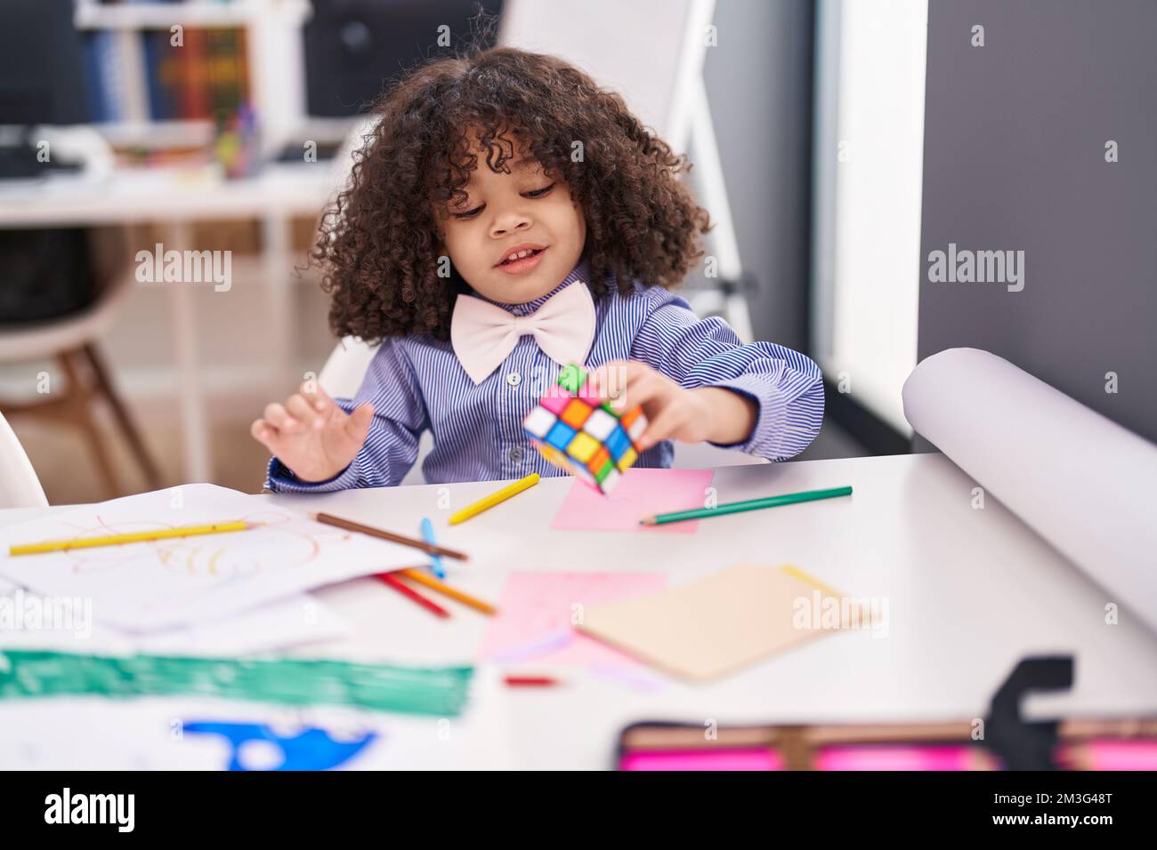 African american toddler preschool student sitting on table solving ...