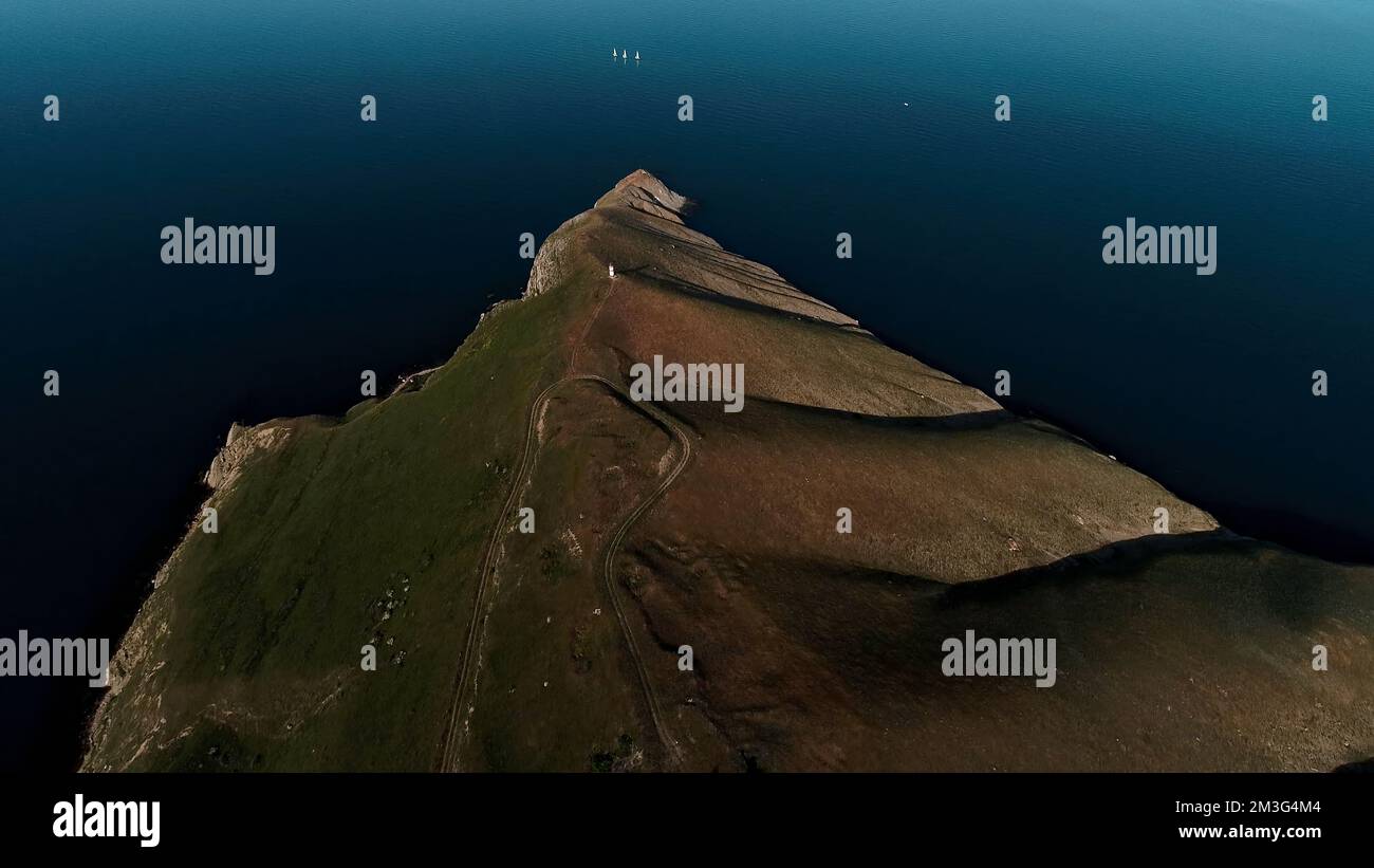 Aerial view of a natural cape and a dark blue sea. Shot. Picturesque ...