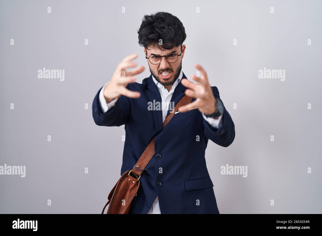 Hispanic man with beard wearing business clothes shouting frustrated ...