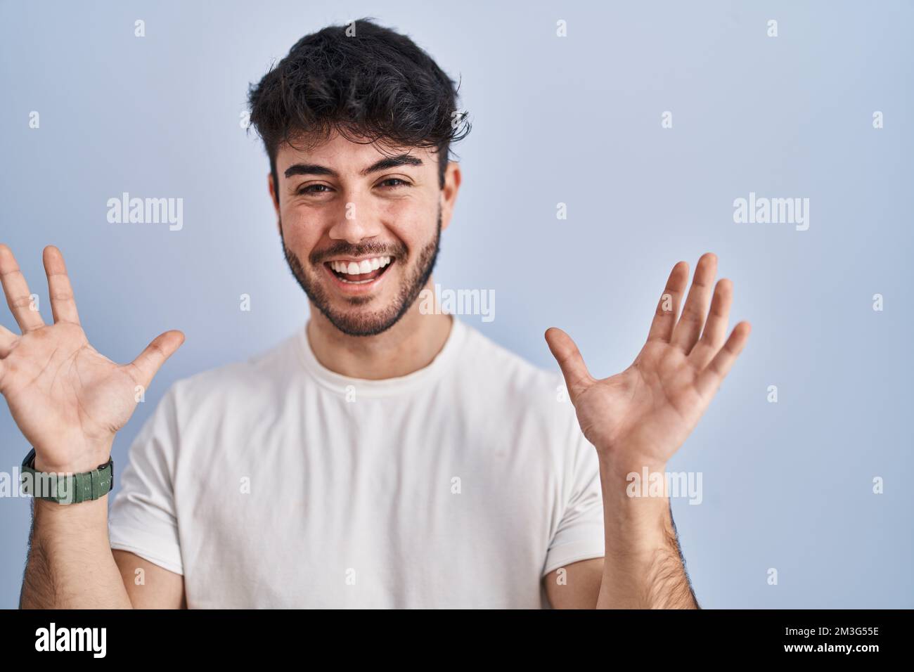 Hispanic man with beard standing over white background celebrating mad ...
