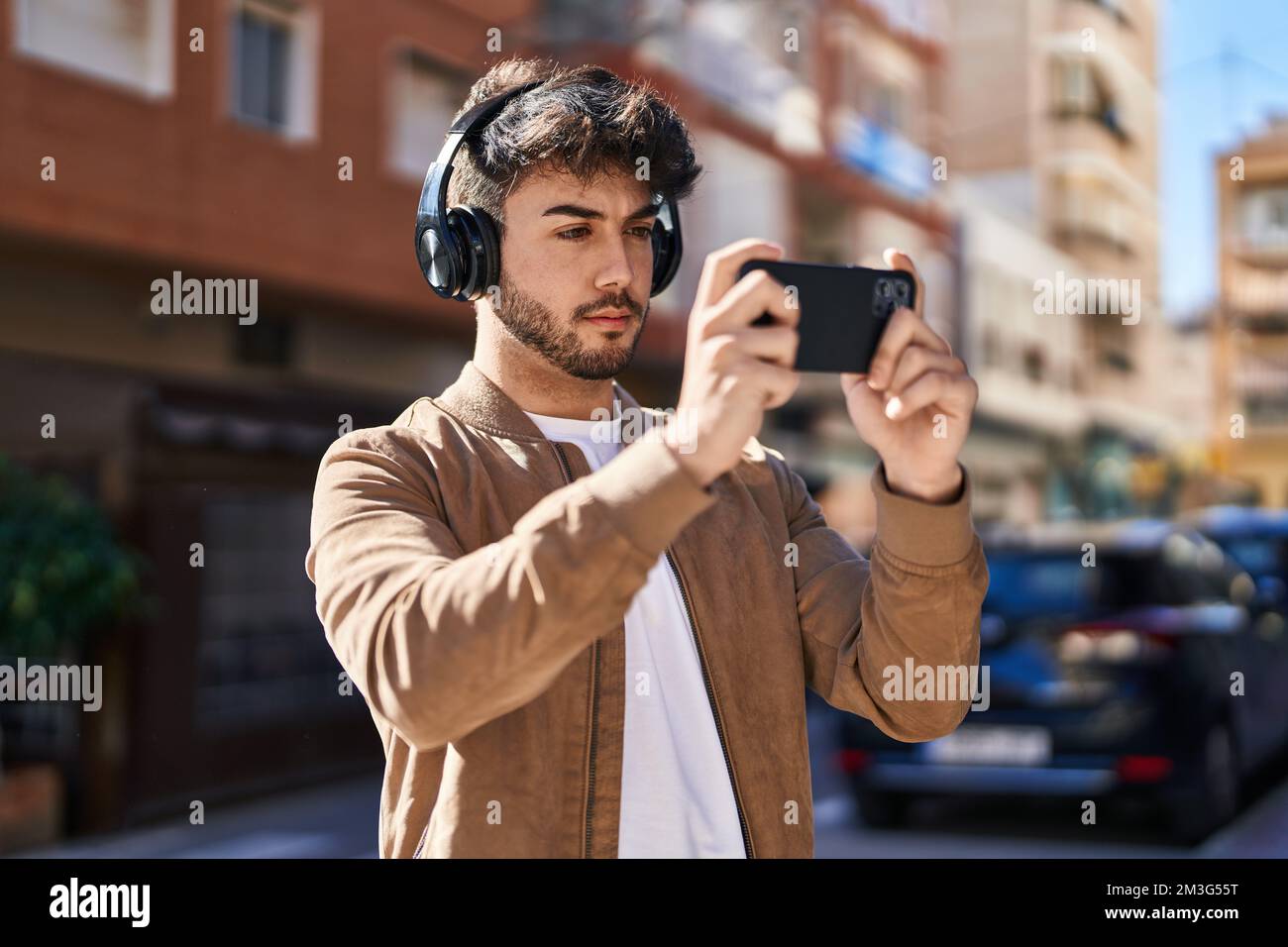 Young hispanic man playing video game at street Stock Photo - Alamy