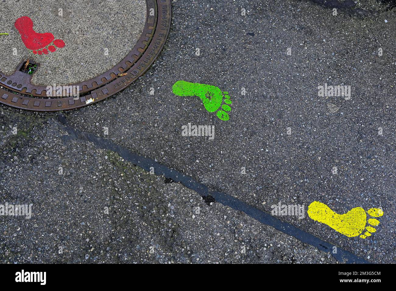 Colourful footprints on manhole covers and asphalt, Kempten, Allgaeu ...
