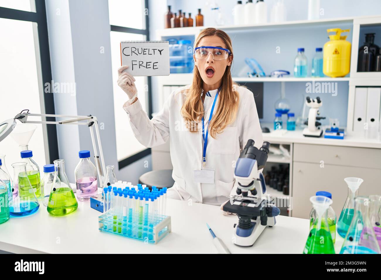 Young blonde scientist woman working on cruelty free laboratory scared ...