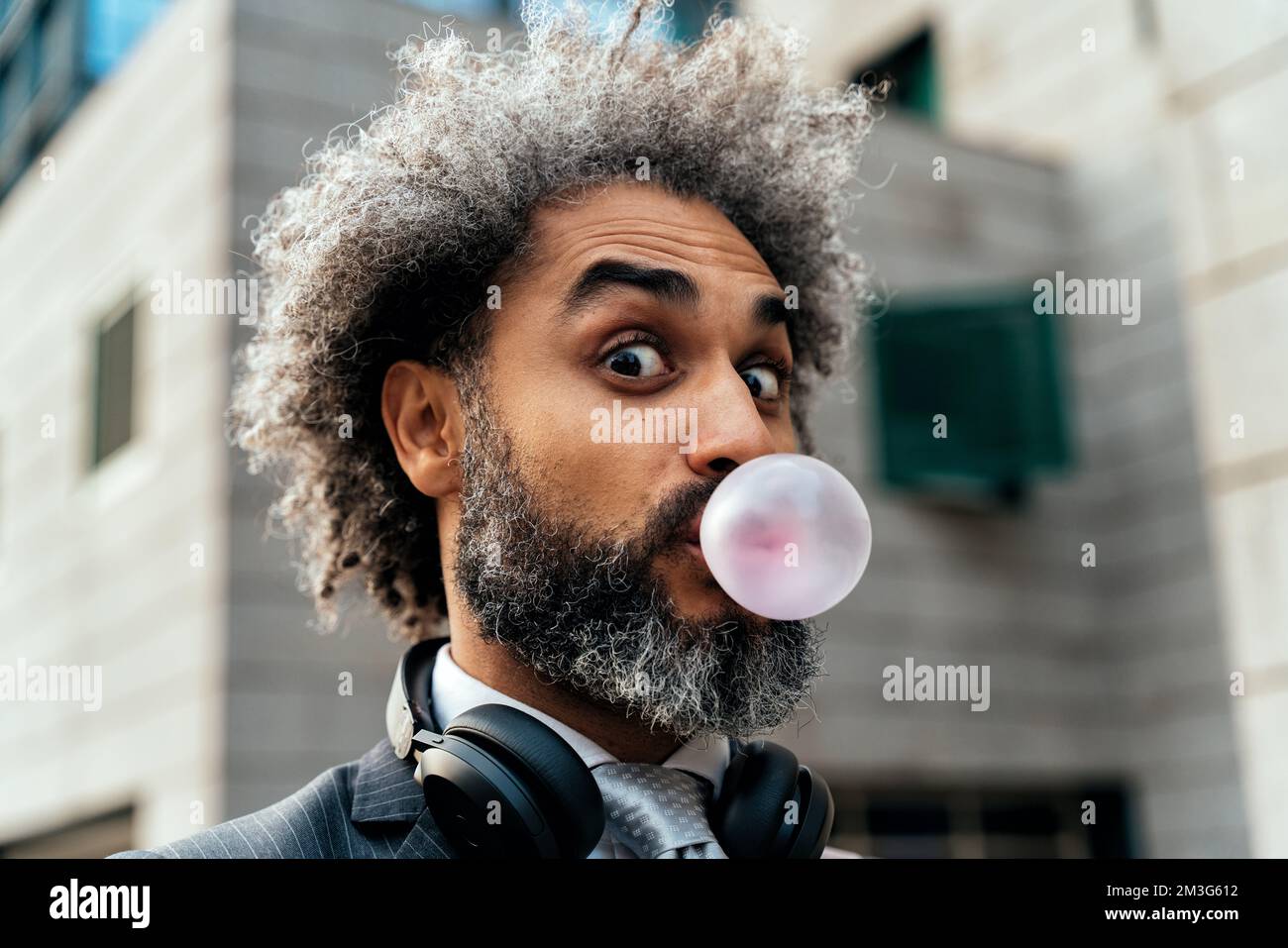 Young entrepreneur chewing fruit bubble gum and making balloons Stock ...