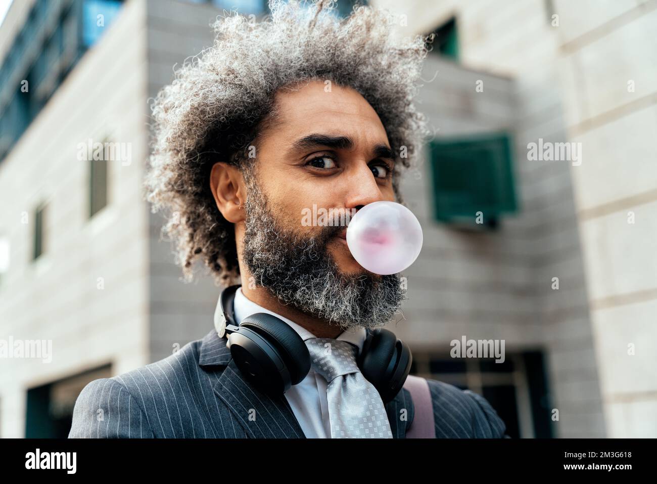 Young entrepreneur chewing fruit bubble gum and making balloons Stock ...