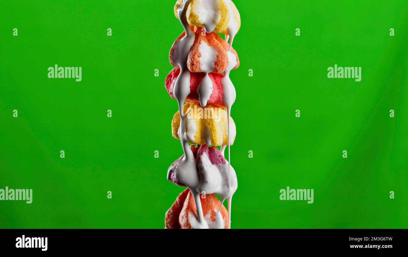 Colorful sweets with cream on green background. Stock clip. Air cookies ...