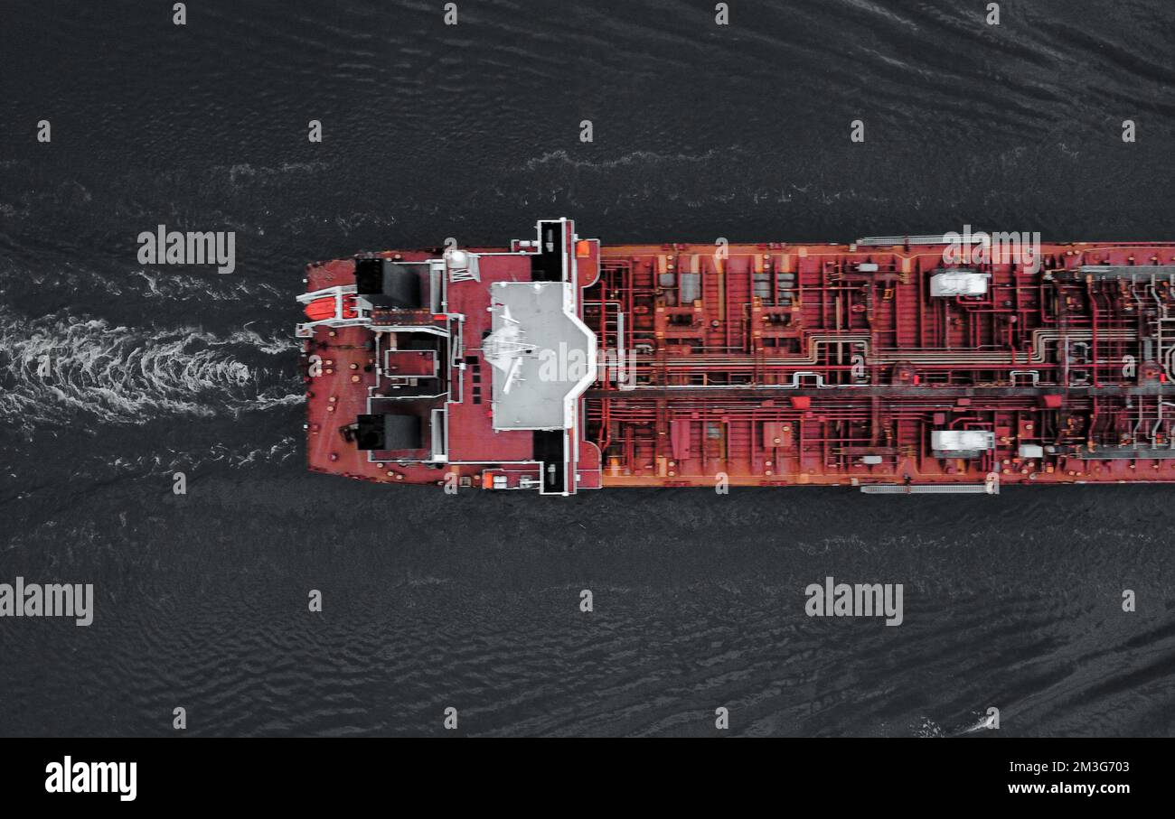 An aerial view over a red cargo ship under the sunlight in a sea Stock ...