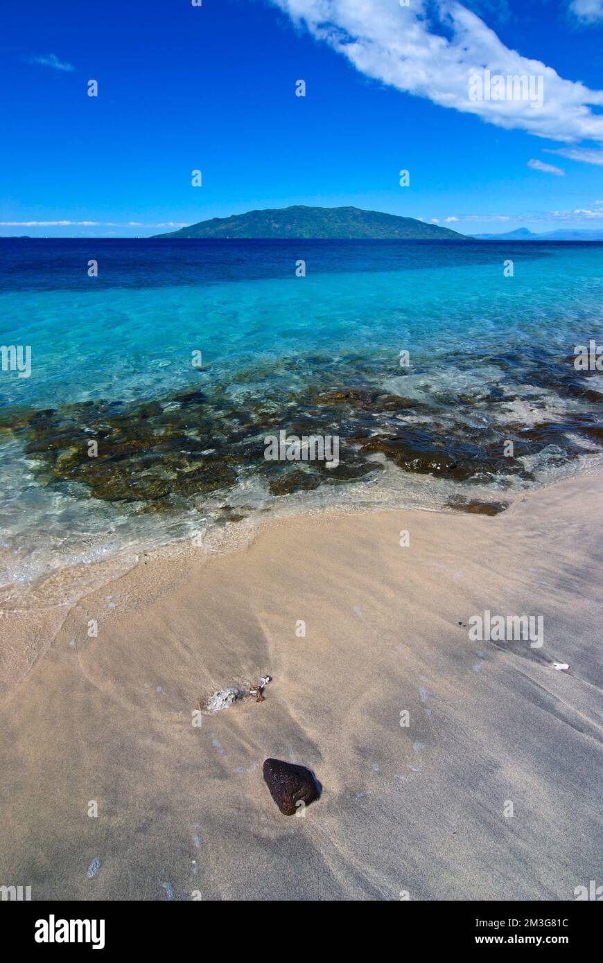 Crystal clear water and white sand beach, in the background Nosy Be ...