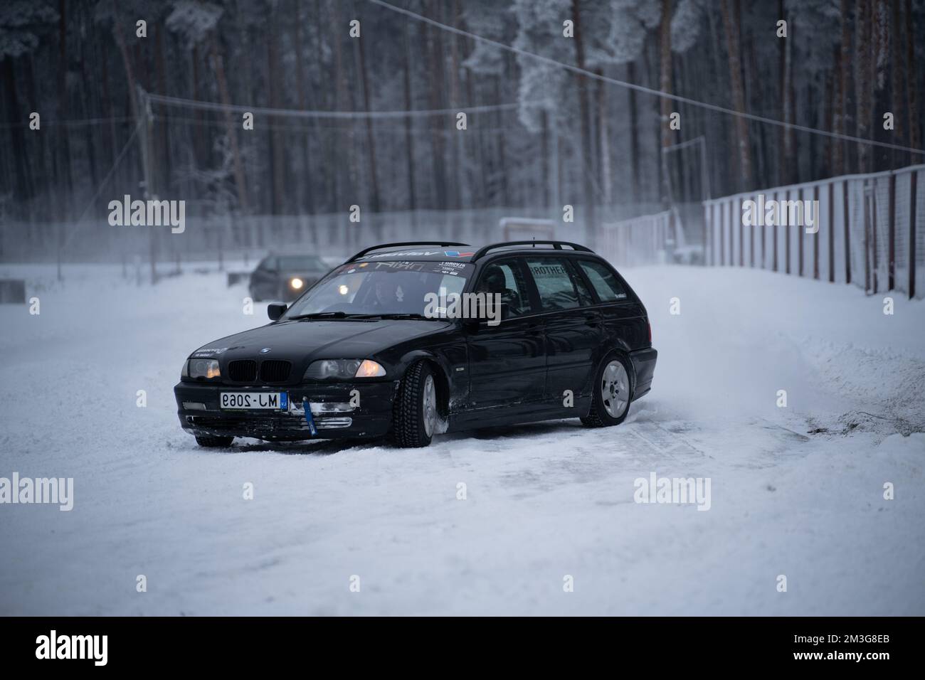 12-12-2022 Riga, Latvia a car is parked in the snow near a fence and ...