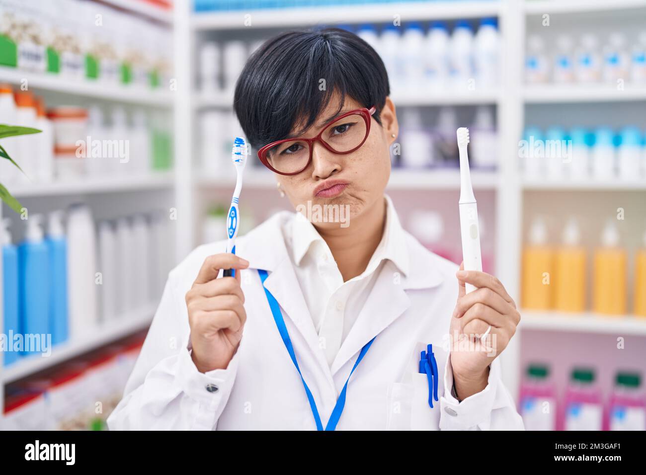 Young asian woman with short hair doing toothbrush comparative at ...