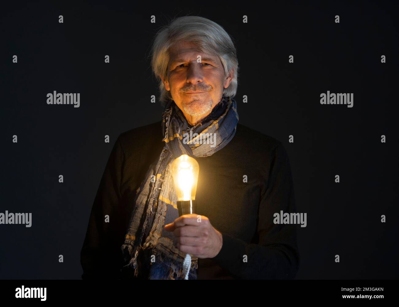 Older gentleman with scarf and light bulb smiles Stock Photo - Alamy