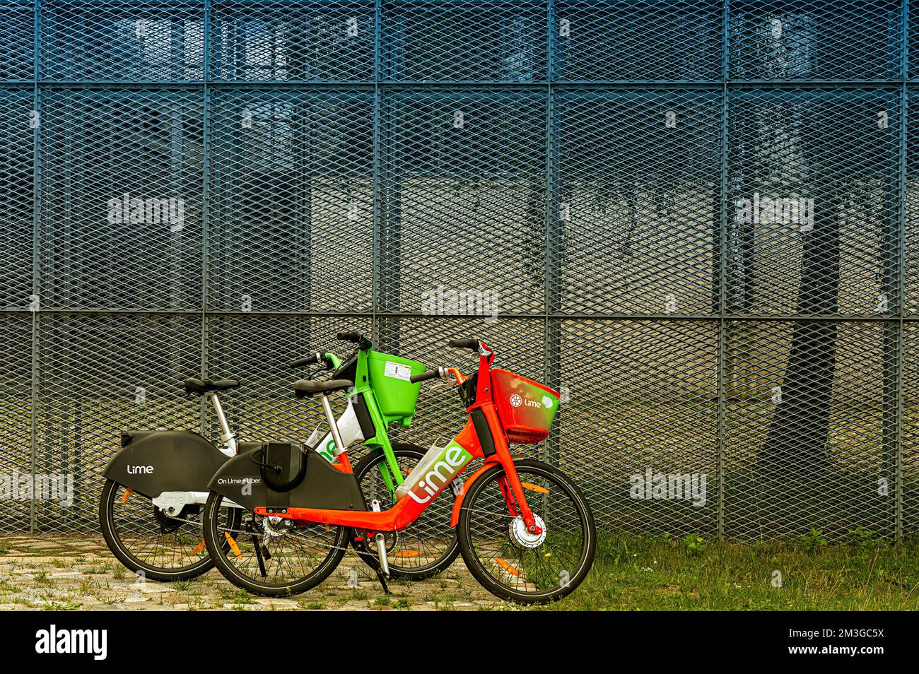 Lime rental bikes in front of high mesh fence, Berlin, Germany Stock ...