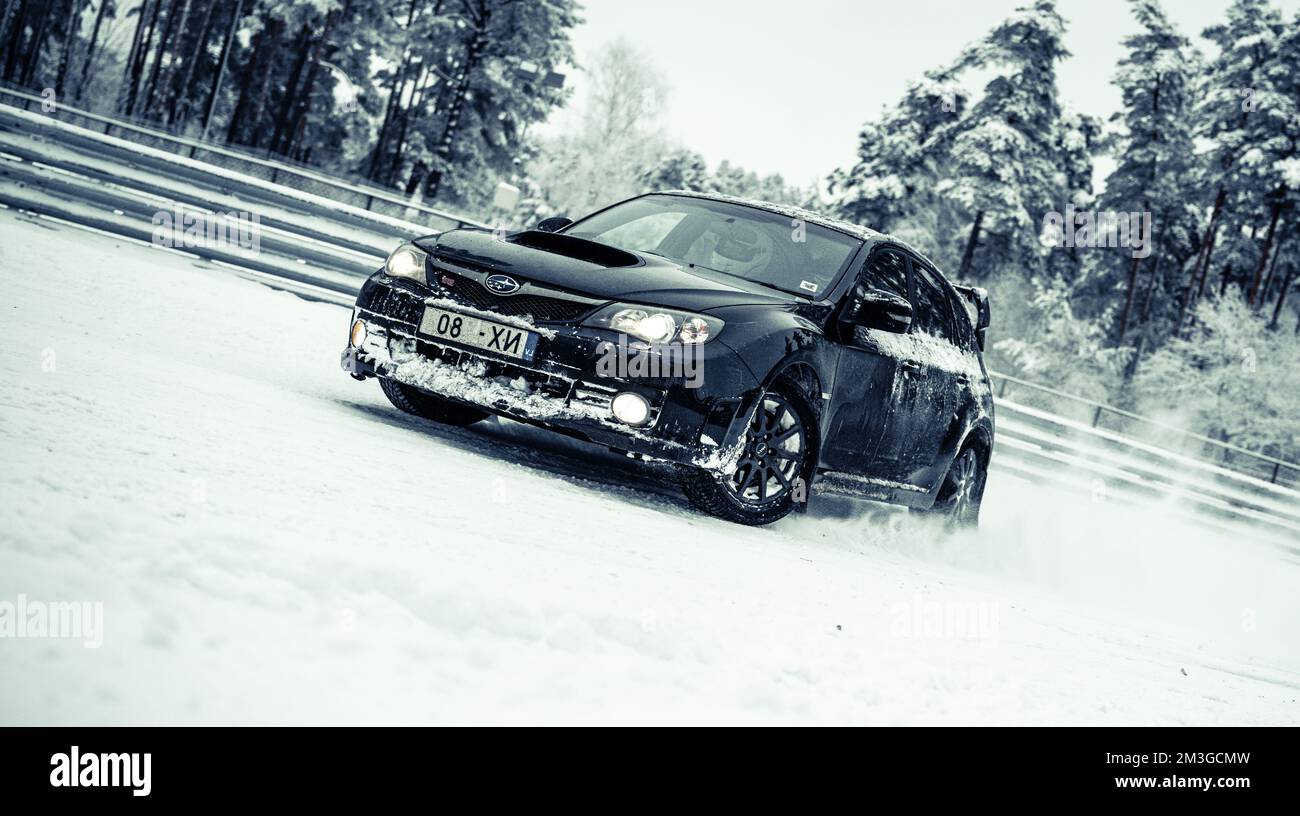 12-12-2022 Riga, Latvia a black car driving down a snow covered road ...