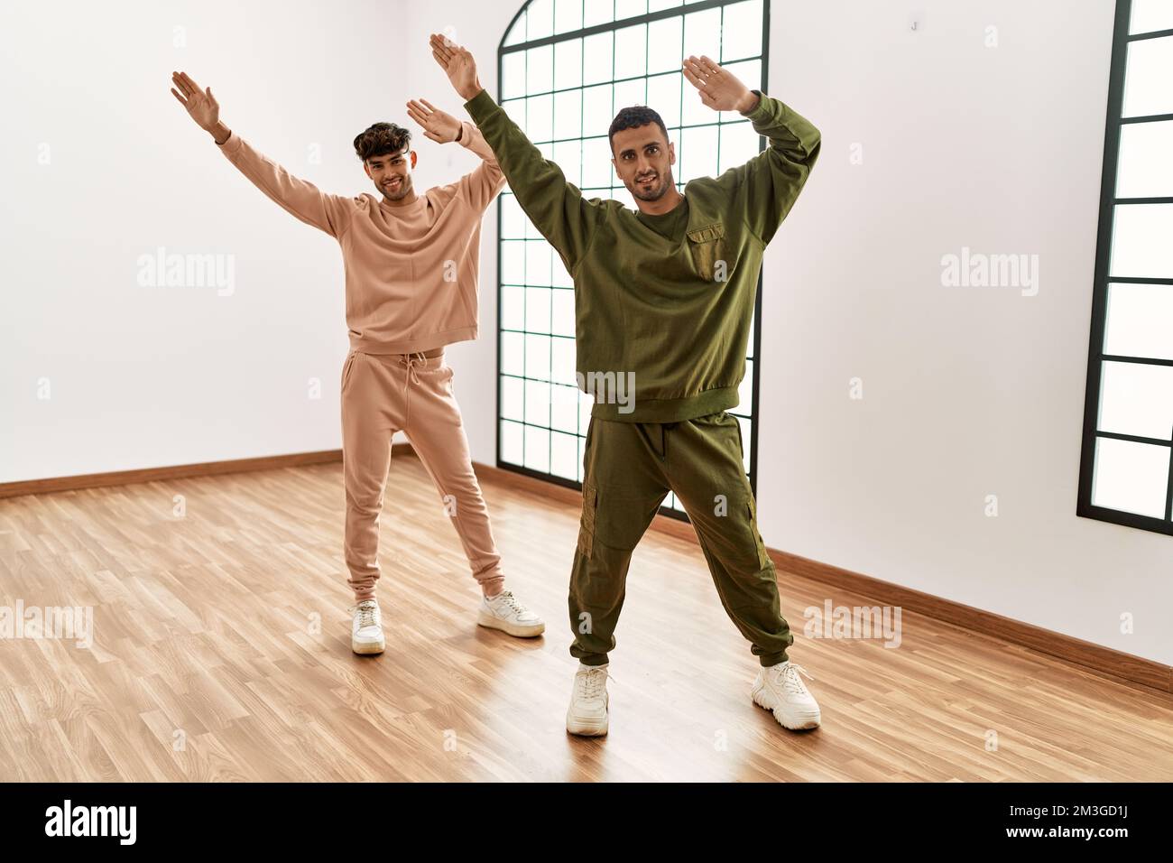 Two hispanic men couple dancers smiling confident dancing at sport ...