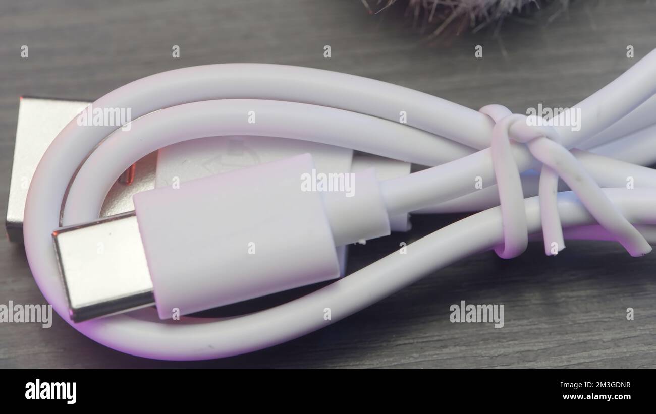Close-up of cable for gadget. Action. Charging cable is white for phone ...