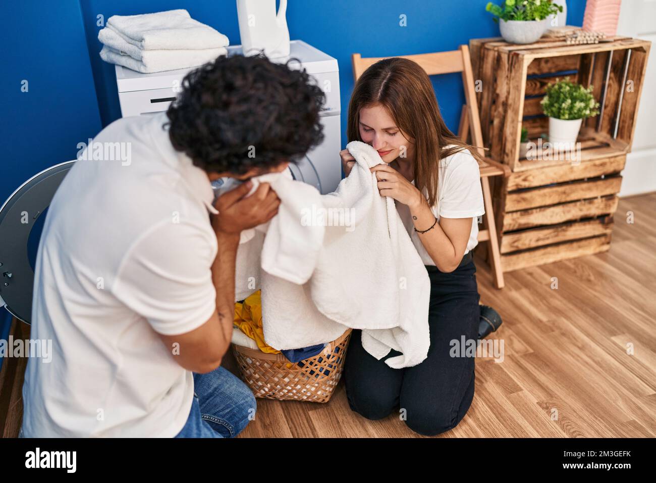 Man and woman couple smiling confident smelling towel at laundry room Stock Photo - Alamy