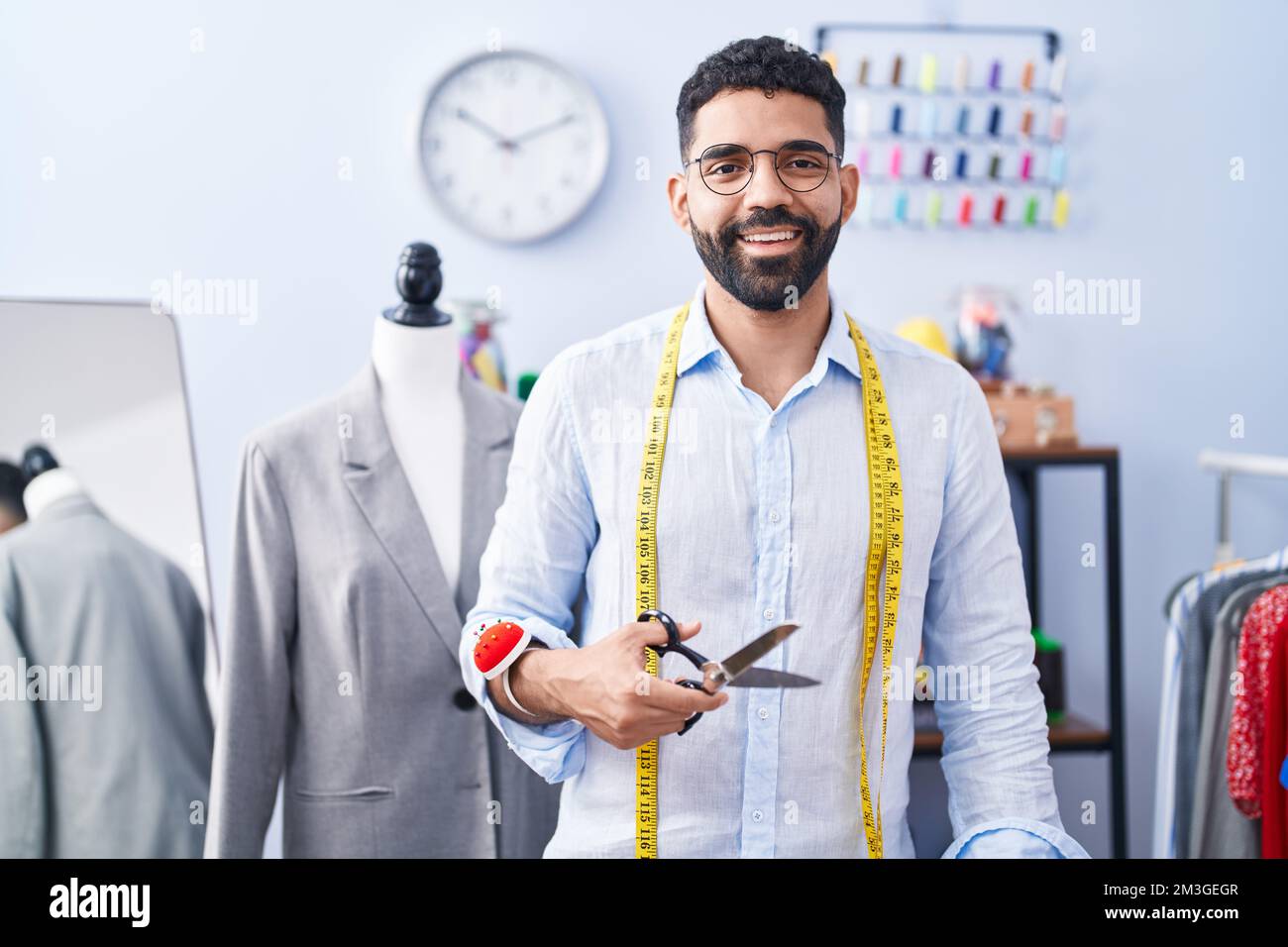 Young arab man tailor smiling confident holding scissors at tailor shop ...