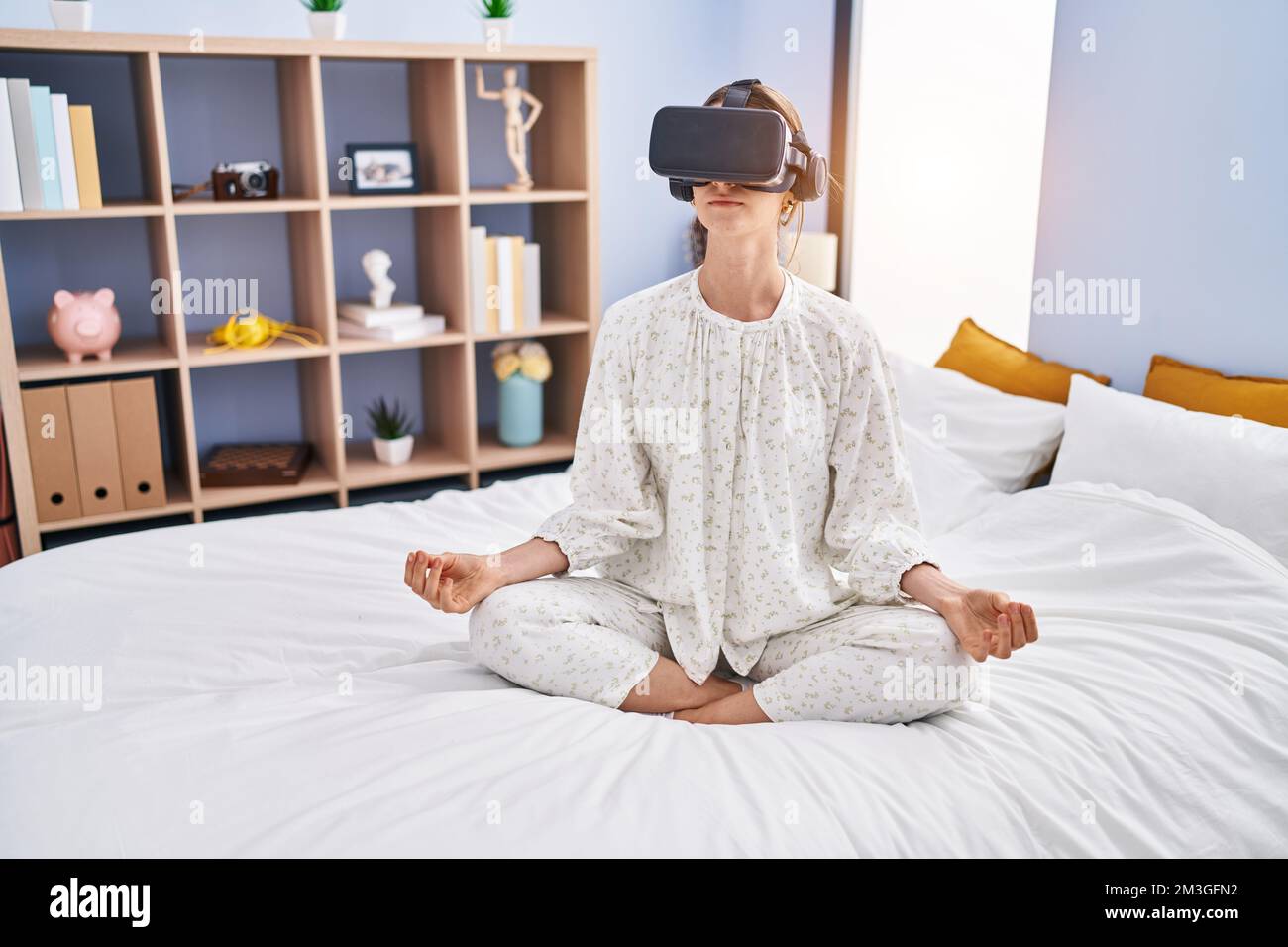 Young caucasian woman doing yoga exercise using virtual reality glasses ...