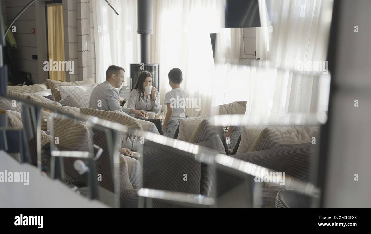 Rich family is eating in luxurious interior. Action. Parents with child ...