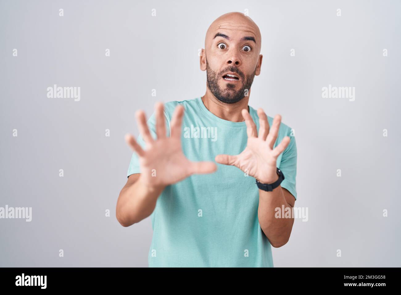 Middle age bald man standing over white background afraid and terrified ...