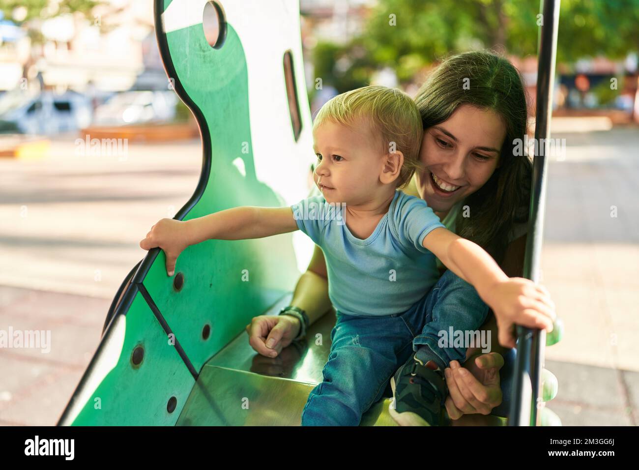 Mother and son smiling confident playing on slide at park playground Stock Photo - Alamy