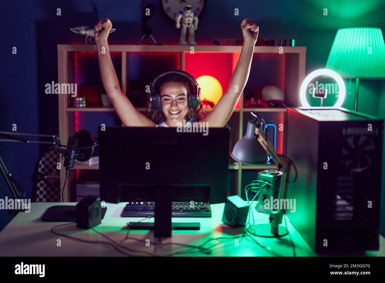 Young beautiful hispanic woman streamer playing video game with winner ...