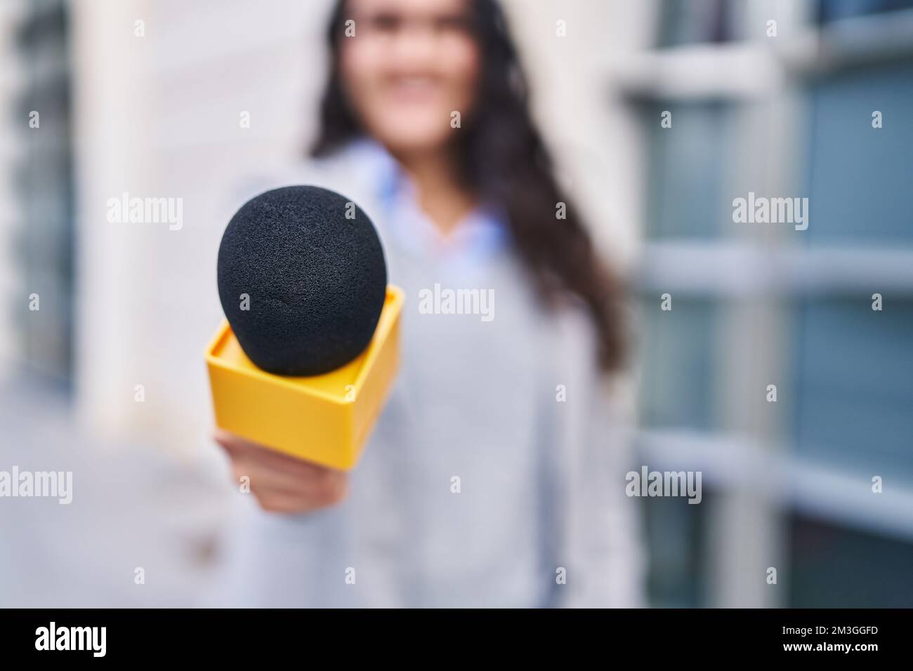 Young hispanic woman reporter working using microphone at street Stock ...
