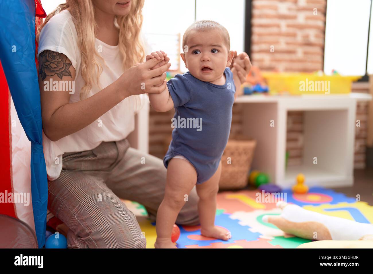 Teacher and preschool student standing with relaxed expression at ...