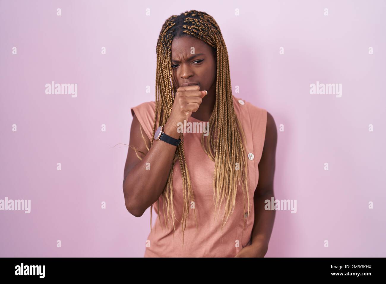 African american woman with braided hair standing over pink background ...