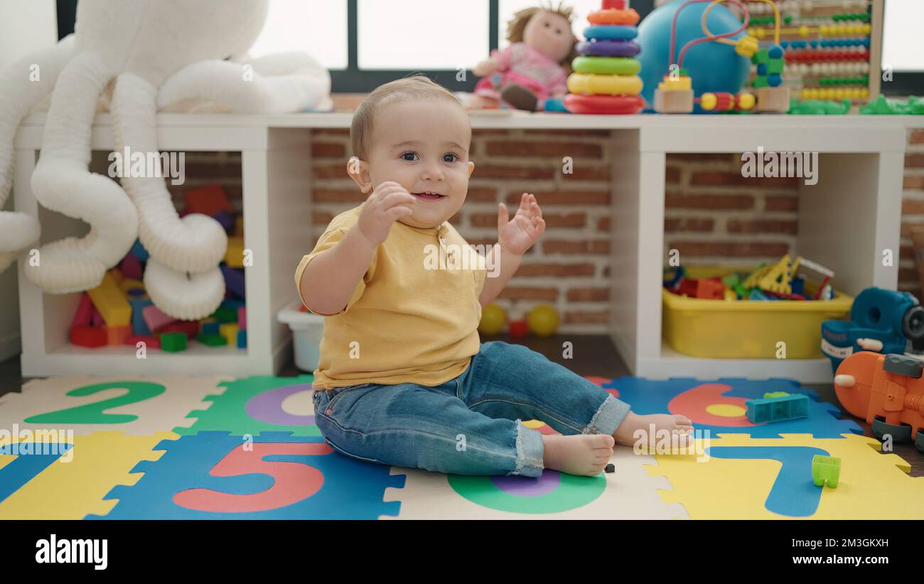 Adorable hispanic baby smiling confident sitting on floor at ...
