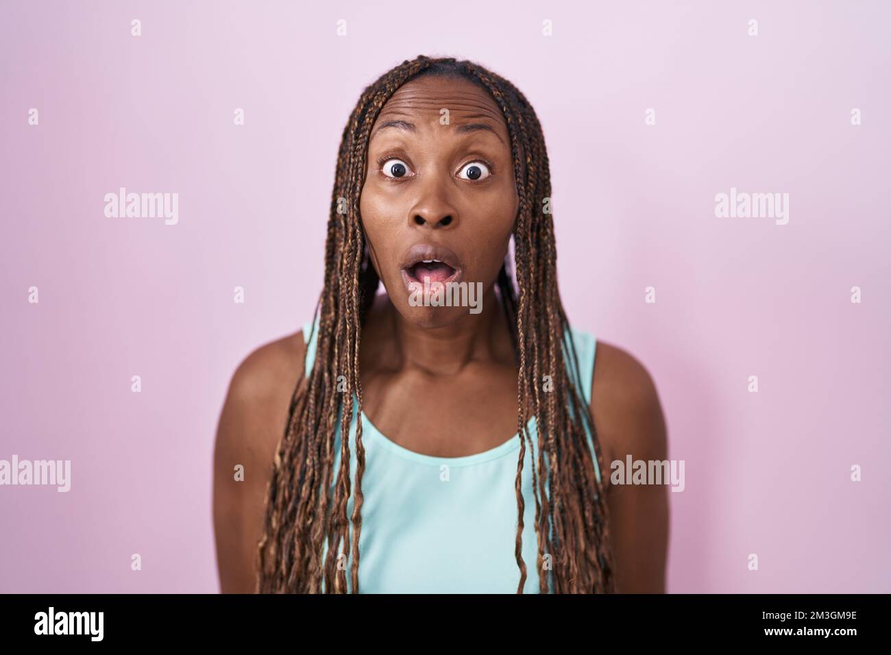 African american woman standing over pink background afraid and shocked ...