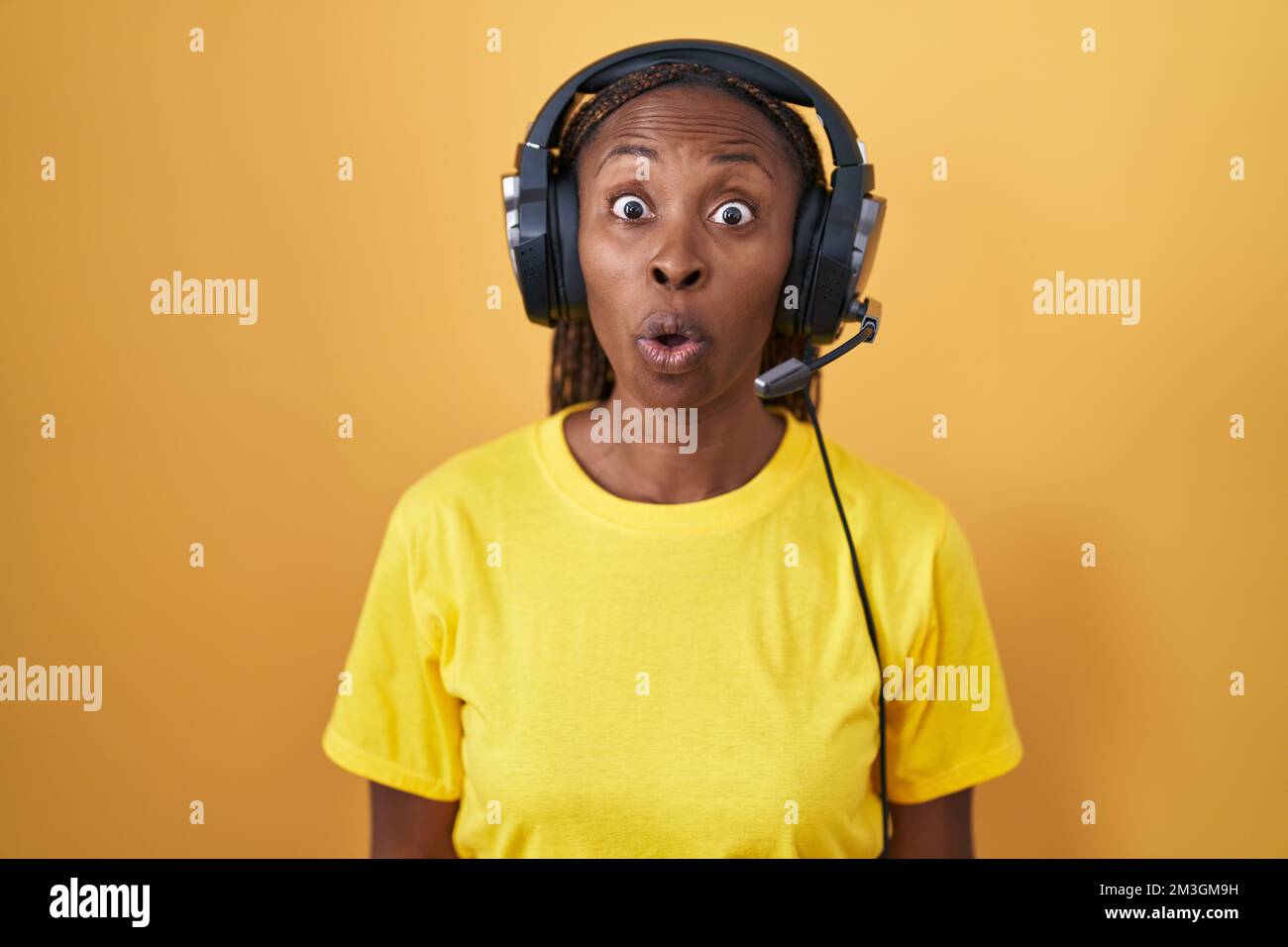 African american woman listening to music using headphones afraid and ...