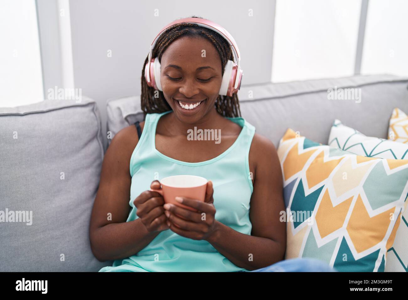 African american woman listening to music drinking coffee at home Stock ...