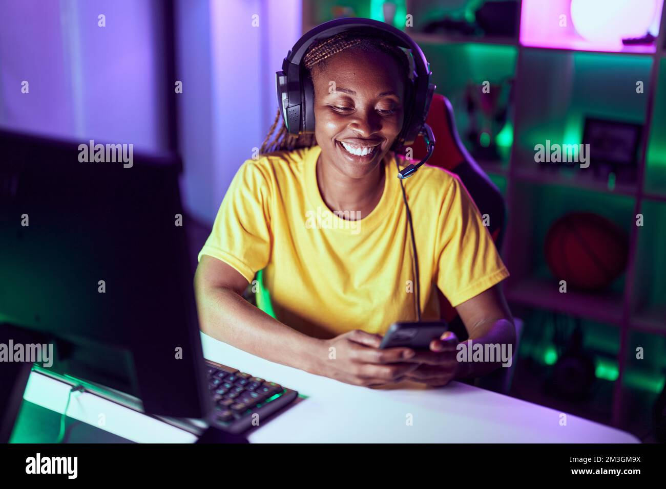 African american woman streamer playing video game using smartphone at ...