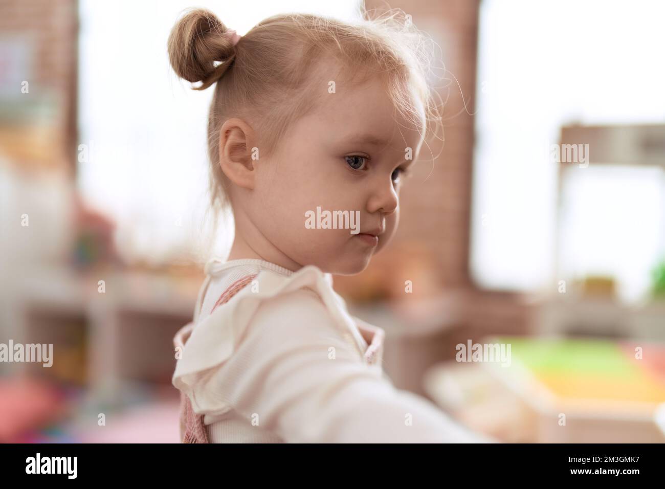 Adorable caucasian girl standing with relaxed expression at ...