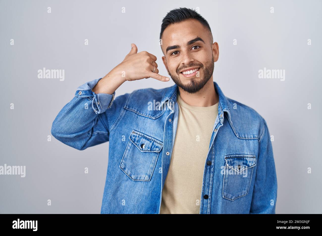 Young hispanic man standing over isolated background smiling doing ...