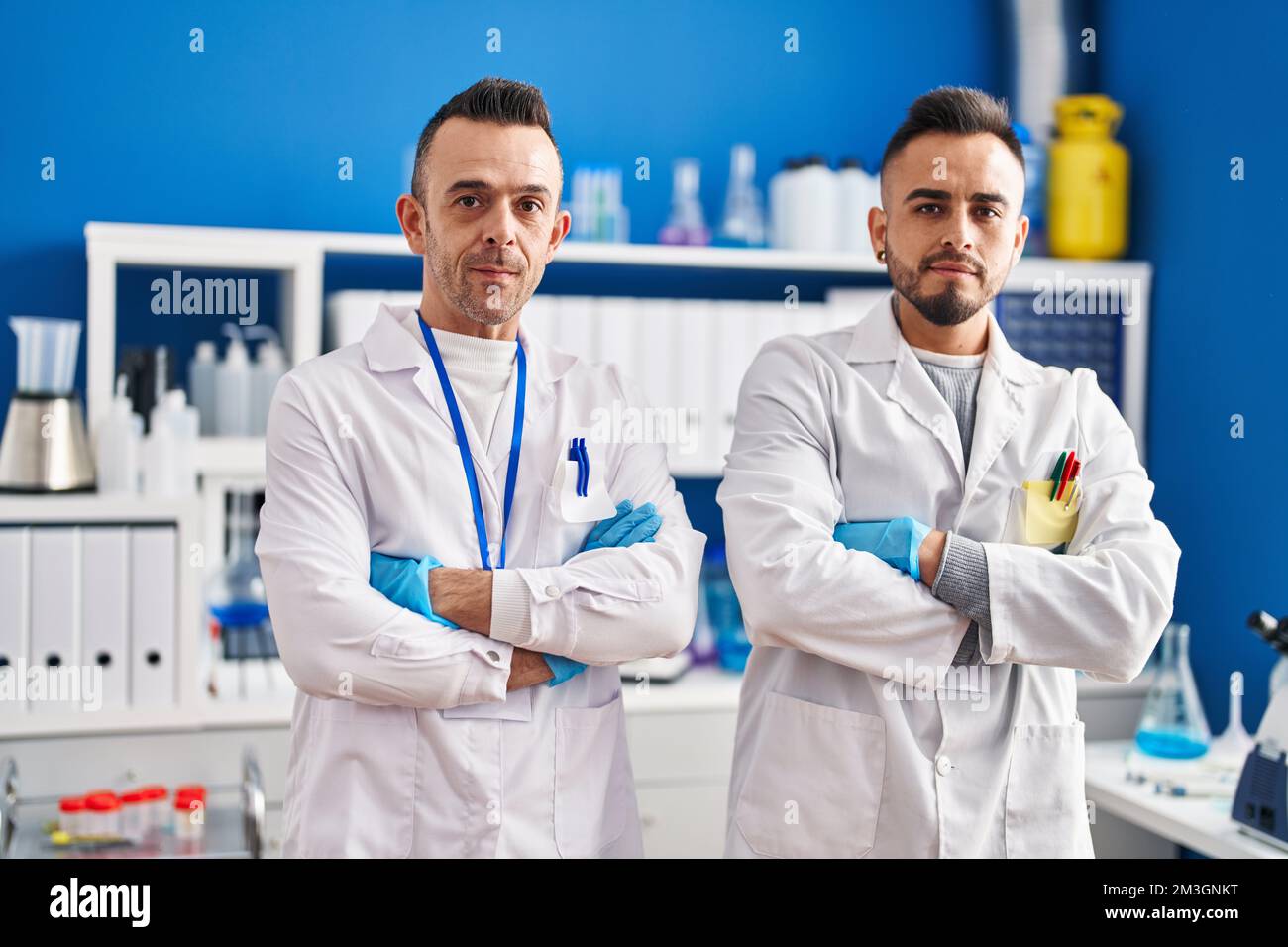 Two men scientists standing with relaxed expression and arms crossed ...