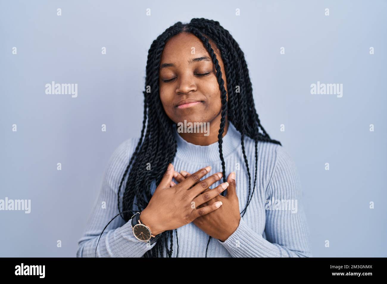 African american woman standing over blue background smiling with hands ...