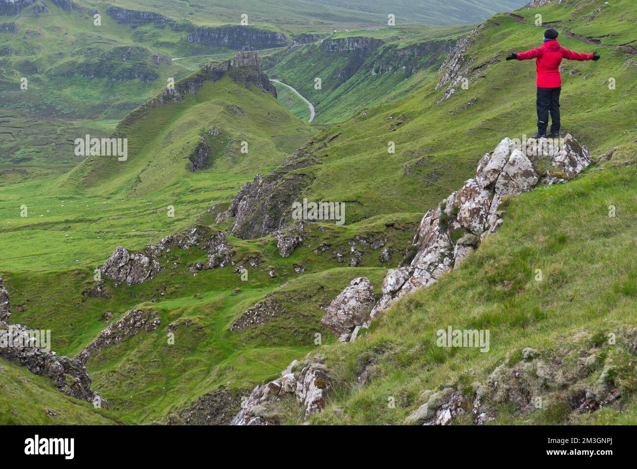 Hiker in red outdoor jacket in the bizarre rock world of Quiraing ...
